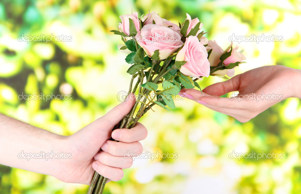 Man's hand giving a roses on bright background Stock Photo by ...