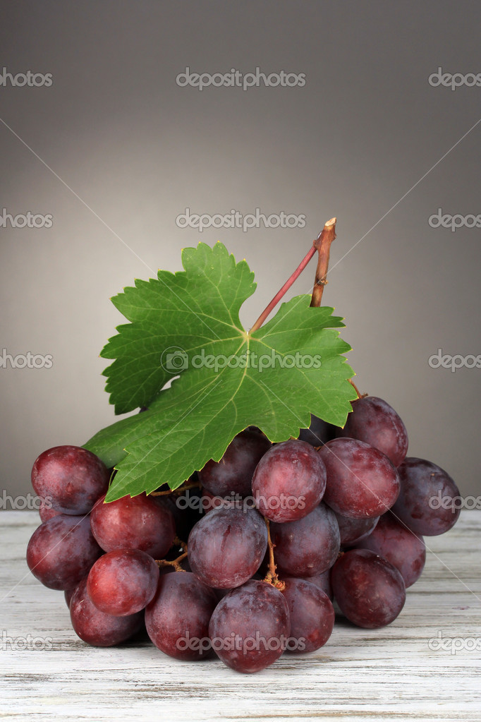 Ripe delicious grapes on table on gray background — Stock Photo ...