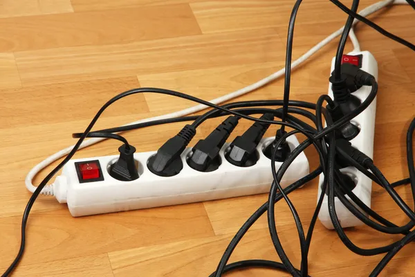 Overloaded power board, on wooden floor background Stock Photo by ...