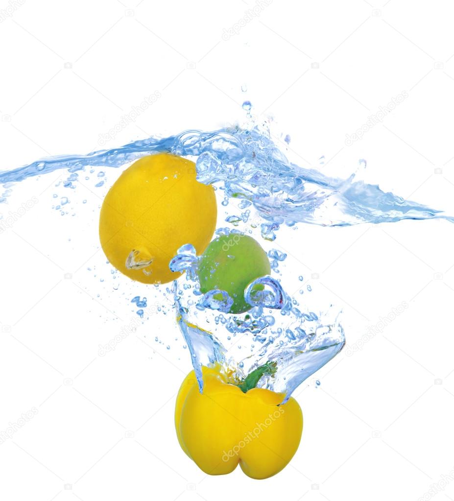Tropical fruits and vegetables falling into water with splash isolated ...