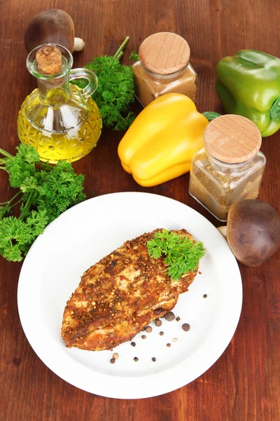 Roasted chicken fillets on white plate and vegetables, on wooden ...