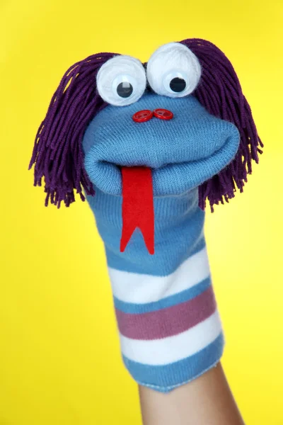 Cute sock puppet on yellow background Stock Photo by ©belchonock 34495967