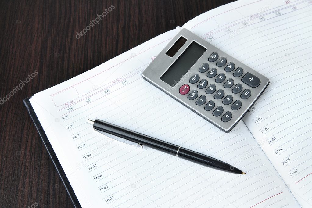 Notebook with pen and calculator on wooden background Stock Photo by ...