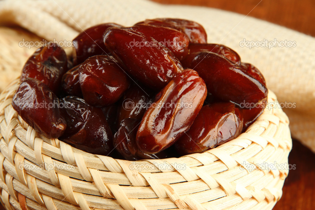 Dried dates in basket on table close up Stock Photo by ©belchonock 35207661