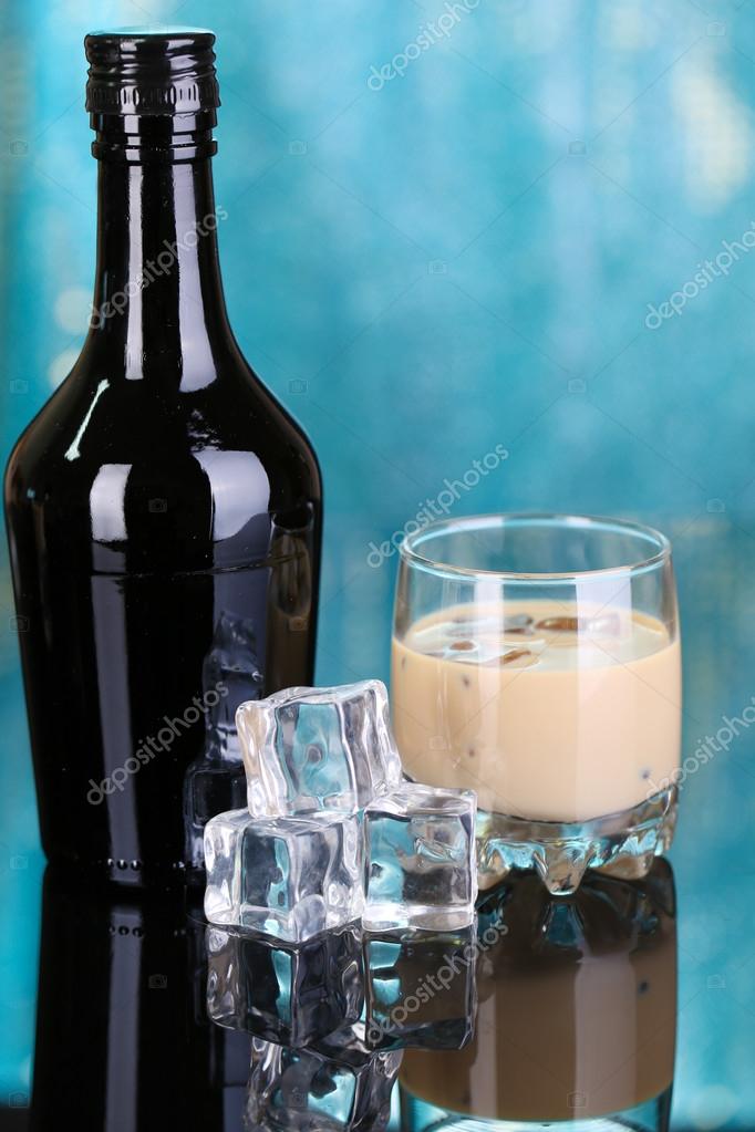 Baileys liqueur in bottle and glass on blue background Stock Photo by ...