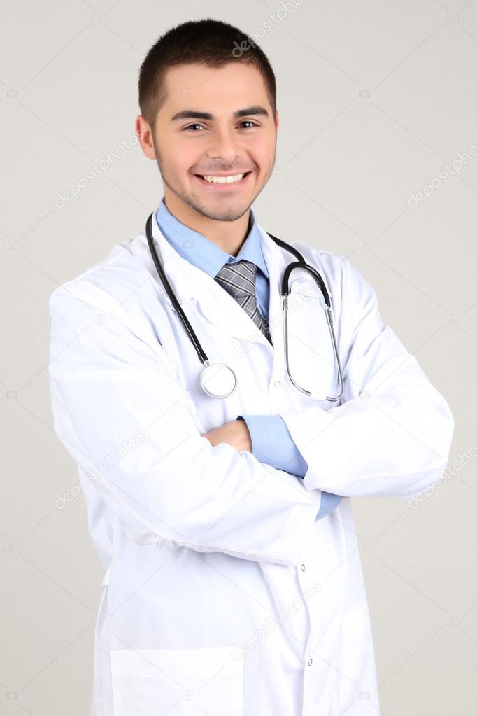 Male Doctor standing on gray background Stock Photo by ©belchonock 38105935