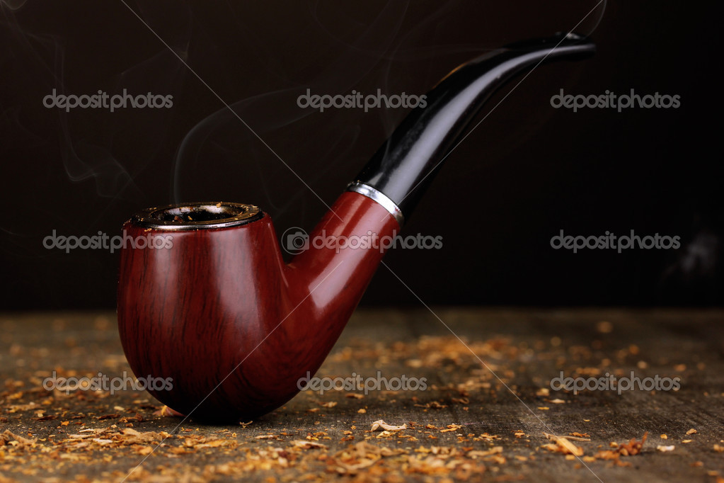 Smoking pipe and tobacco on wooden table on black background Stock ...