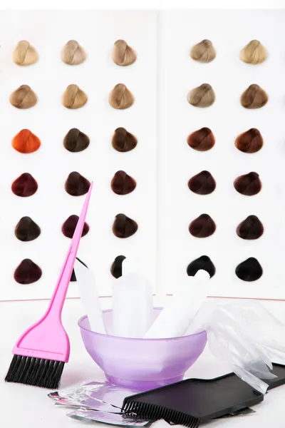 Hair dye kit on board with hair samples of different colors background ...