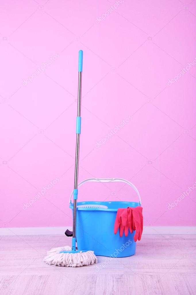 Floor mop and bucket for washing in room on pink wall background Stock ...