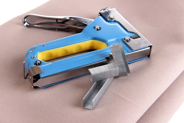 Construction stapler with fabrics and staples on wooden background ...