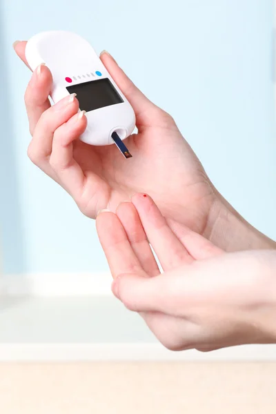 Doctors arm holding glucose meter scanner on patients finger and ...