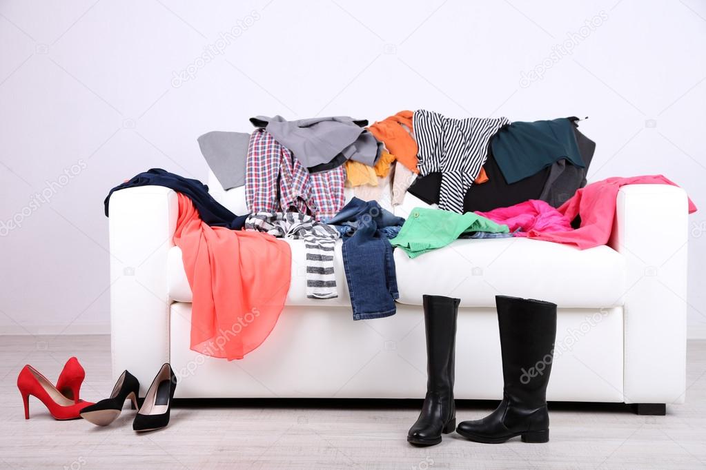 Messy colorful clothing on white sofa on white wall background Stock ...