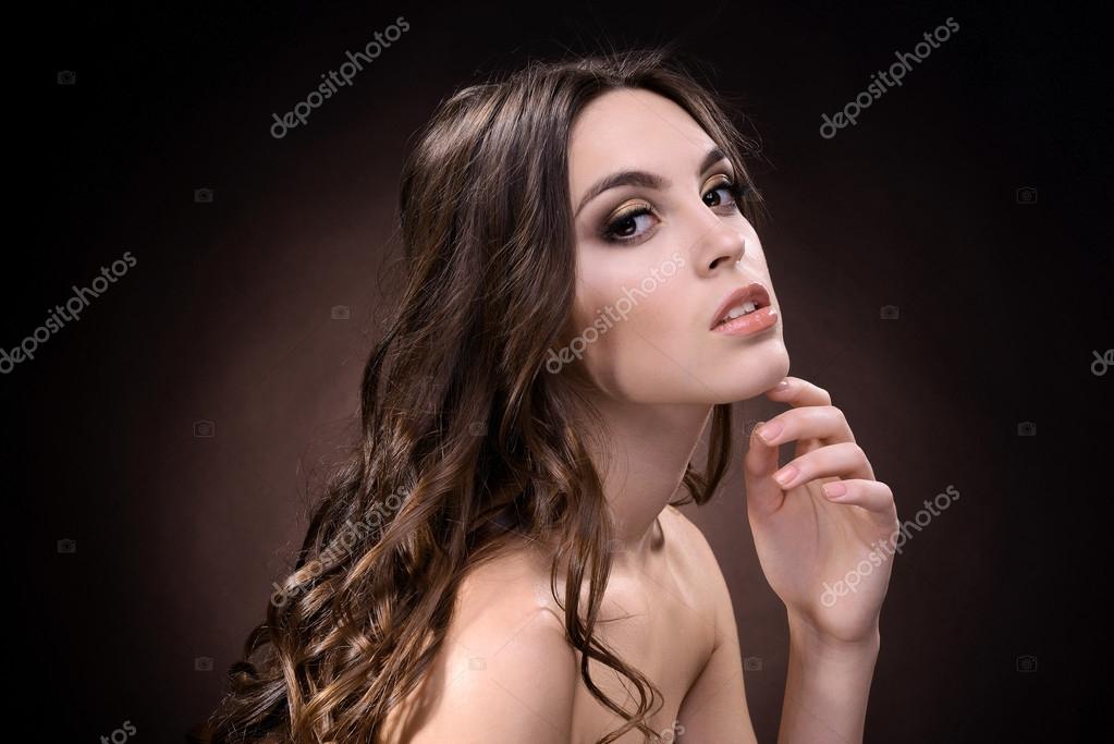 Beautiful young woman with long hair on dark brown background — Stock ...