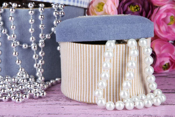 Decorative boxes with beads and flowers on wooden background - Stock ...