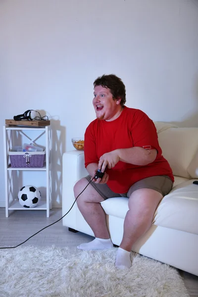 Fat man playing video games Stock Photo by ©belchonock 46203651