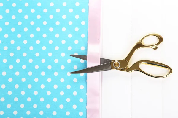 Scissors on color fabric background Stock Photo by ©belchonock 44966817