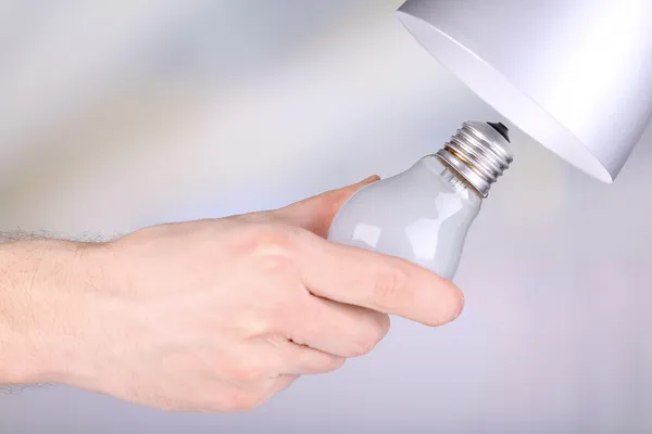 Hand changing light bulb for lamp at home - Stock Image - Everypixel