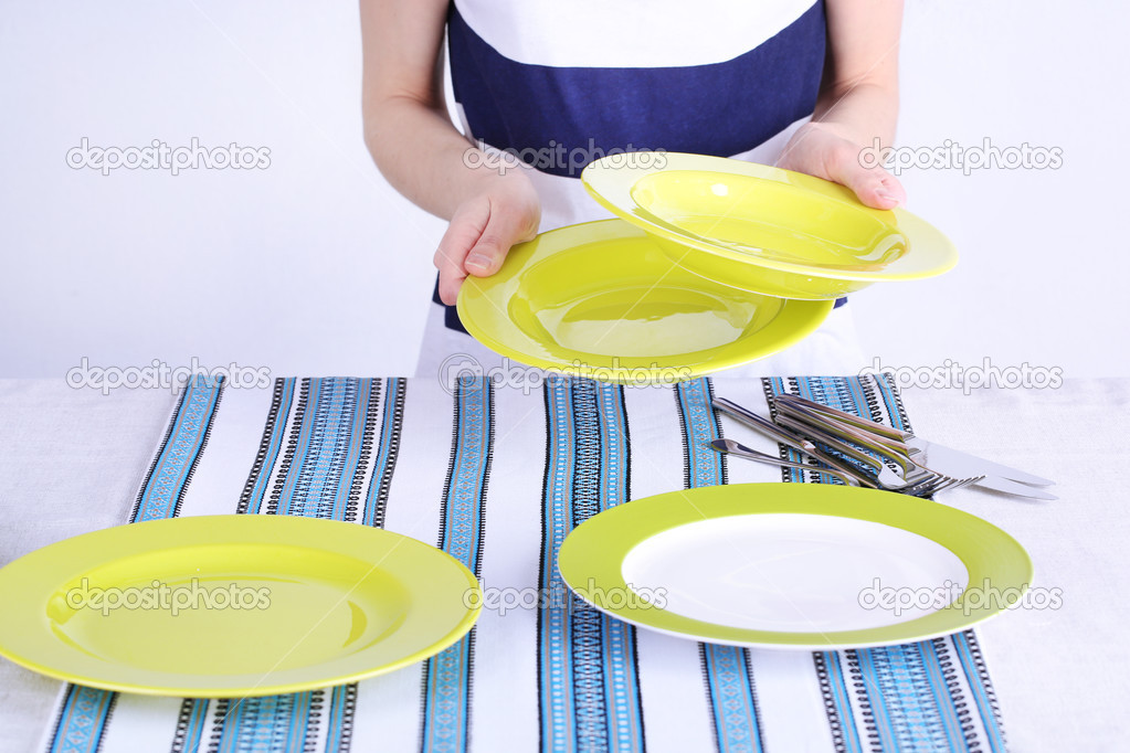 Woman laying table in room — Stock Photo © belchonock #48398717