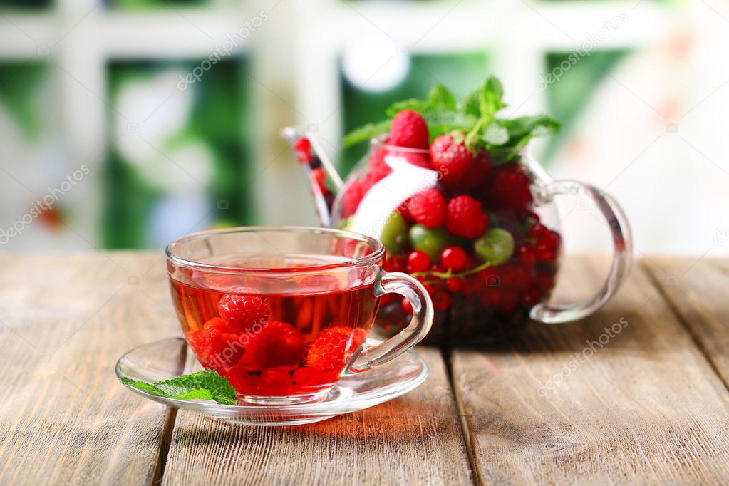 Fruit red tea with wild berries in glass cup, on wooden table, on ...