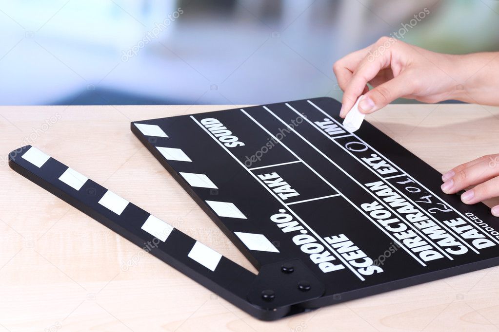 Black cinema clapper board in hands Stock Photo by ©belchonock 48900457