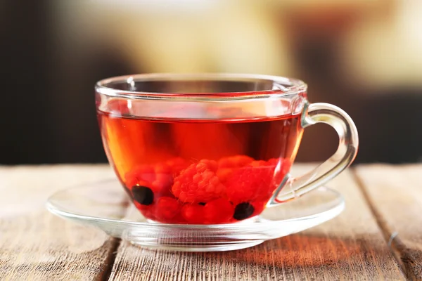 Fruit red tea with wild berries in glass cup, on wooden table, on ...