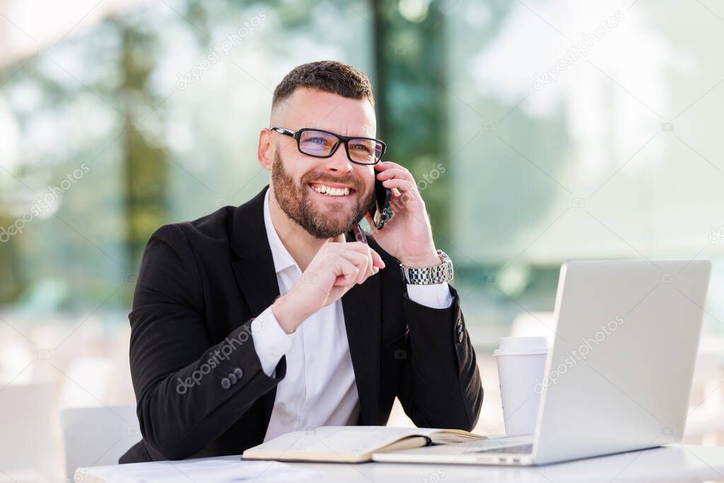 Hombre de negocios sonriente disfrutando de una agradable conversación ...
