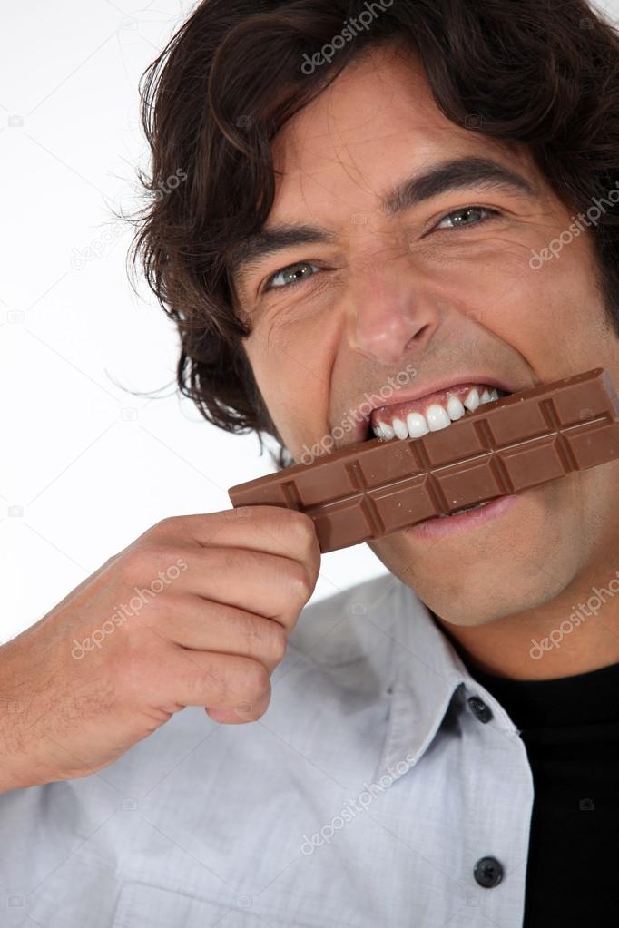 Man eating a bar of chocolate — Stock Photo © photography33 #14559343