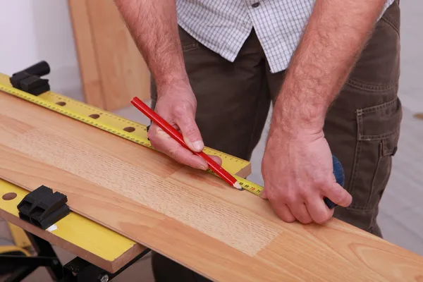 Hand of a carpenter taking measurement of a wooden plank — Stock Photo ...