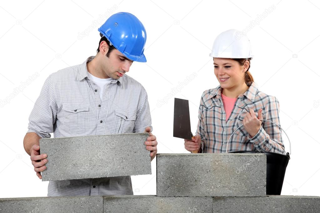 Bricklayer and apprentice with a block wall Stock Photo by ...