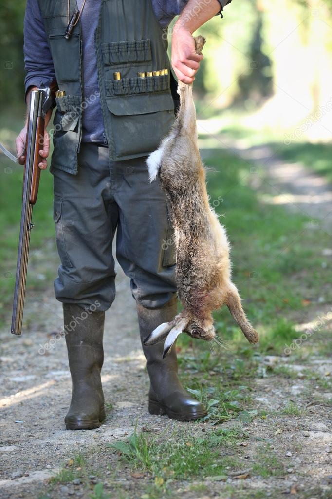 Hunter holding dead rabbit — Stock Photo #18437853