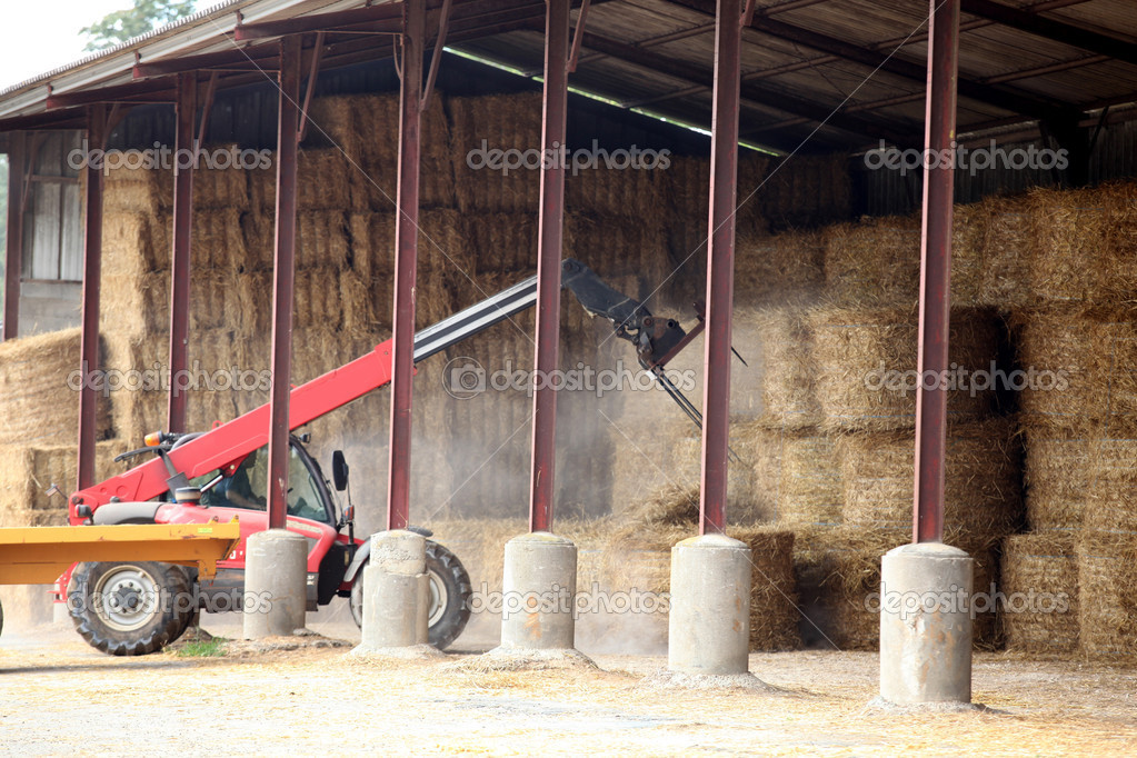 Farm vehicle lifting bails of hay — Stock Photo © photography33 #18478955