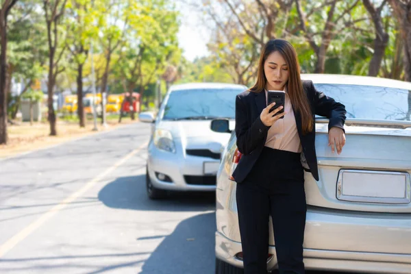 Woman drivers call insurance after a car accident before taking ...