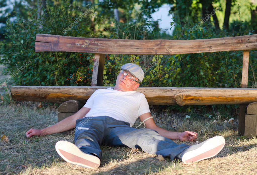 Drug addict lying in a park Stock Photo by ©ampack 30821099