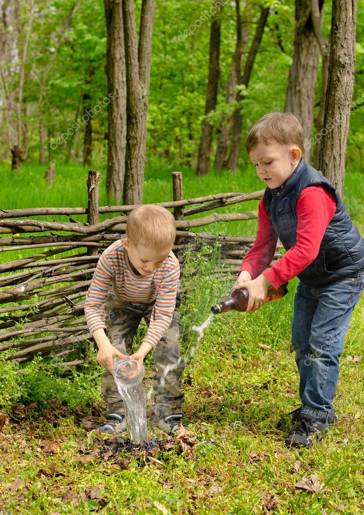 Two young boys extinguishing a small fire — Stock Photo © ampack #47579565