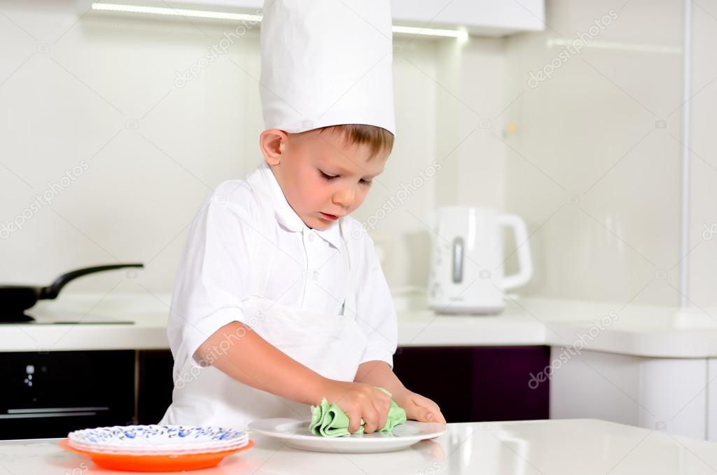 Little boy chef cleaning his plates while cooking Stock Photo by ...