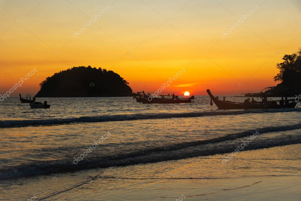 Hermosa puesta de sol y silueta de barcos de cola larga en la playa de ...