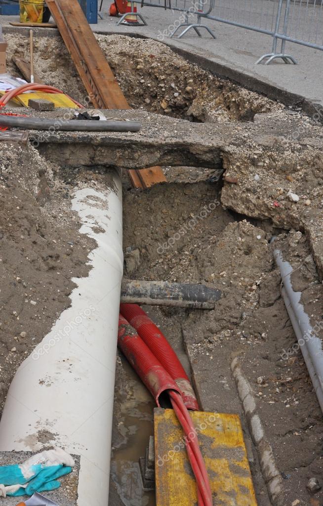 Digging for roadworks during the laying of a conduit for fiber o ...
