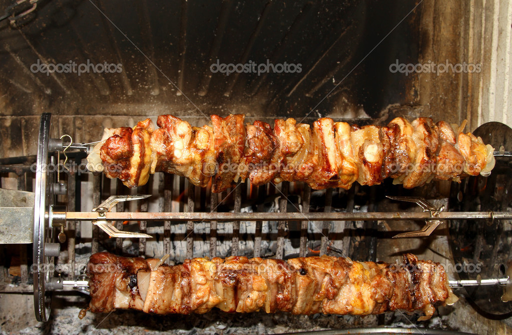 Meat skewers cooked to spit in the fireplace swivel Stock Photo by ...