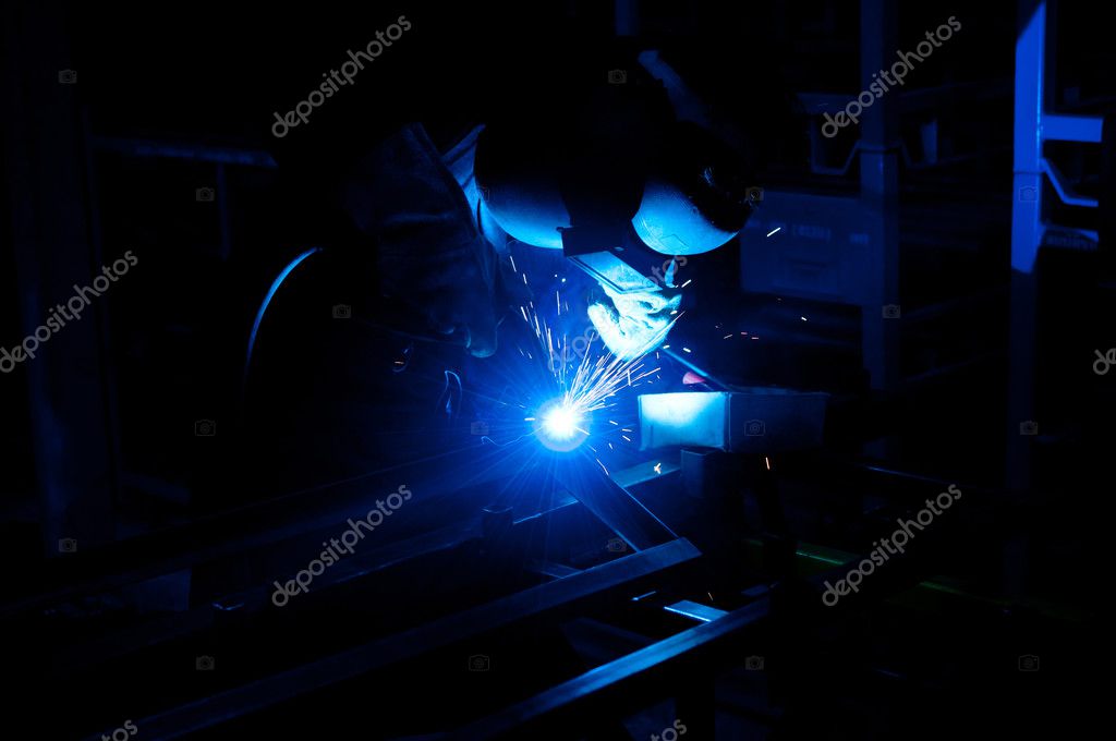Human working of welding with a lot of sparks in a metal industr ...