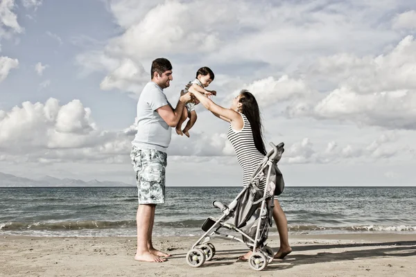 Family running on a sandy beach Stock Photo by ©Goodluz 84003248