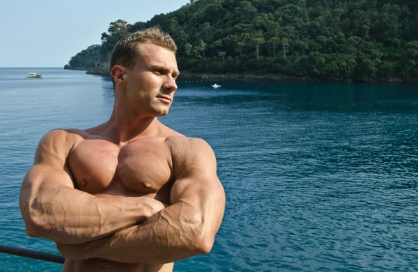 Handsome young bodybuilder shirtless by the sea or ocean — Stock Photo ...