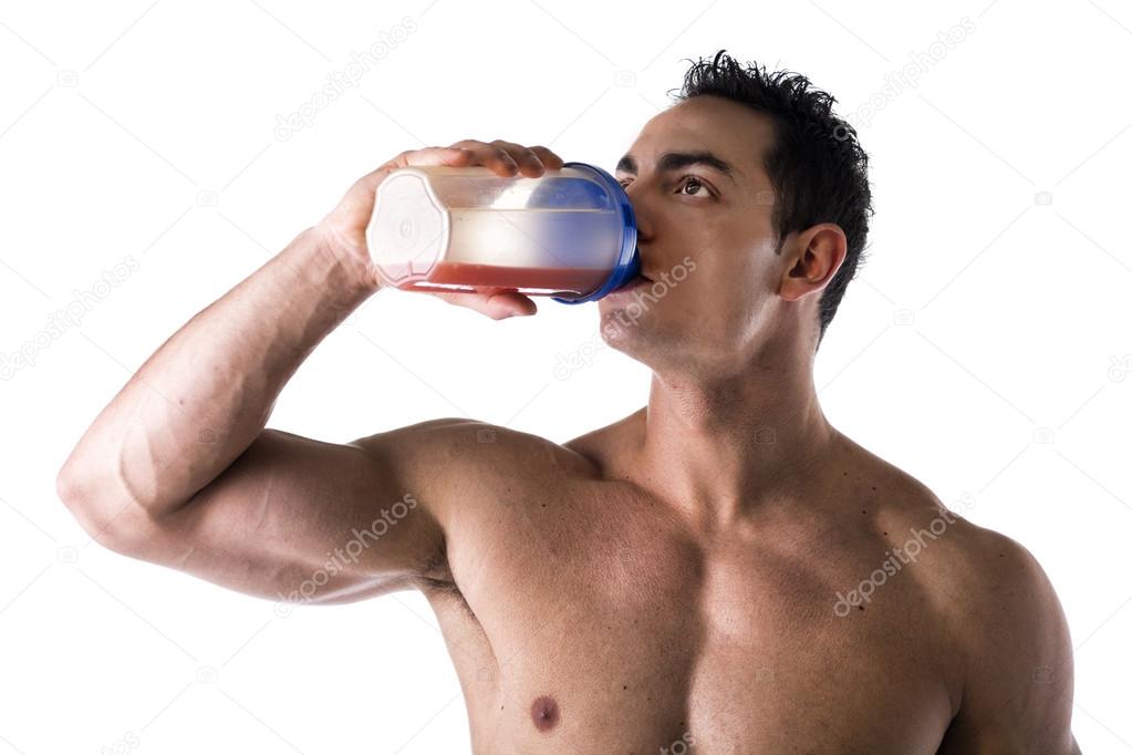 Muscular shirtless male bodybuilder drinking protein shake from blender ...