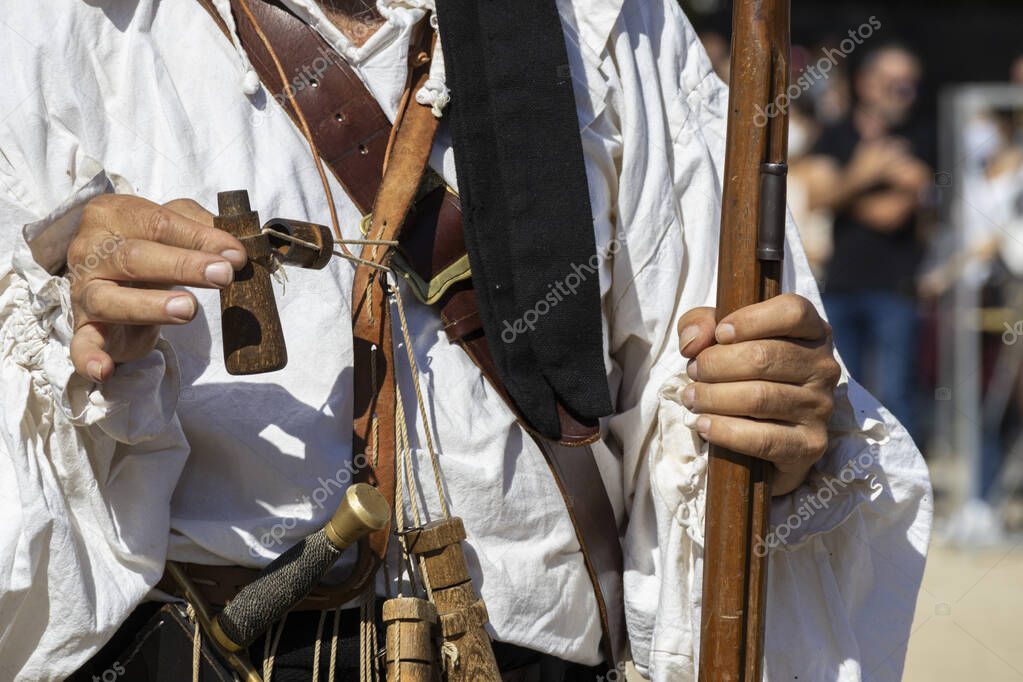 mano en primer plano que muestra el sistema de carga de un arcabuz. El ...