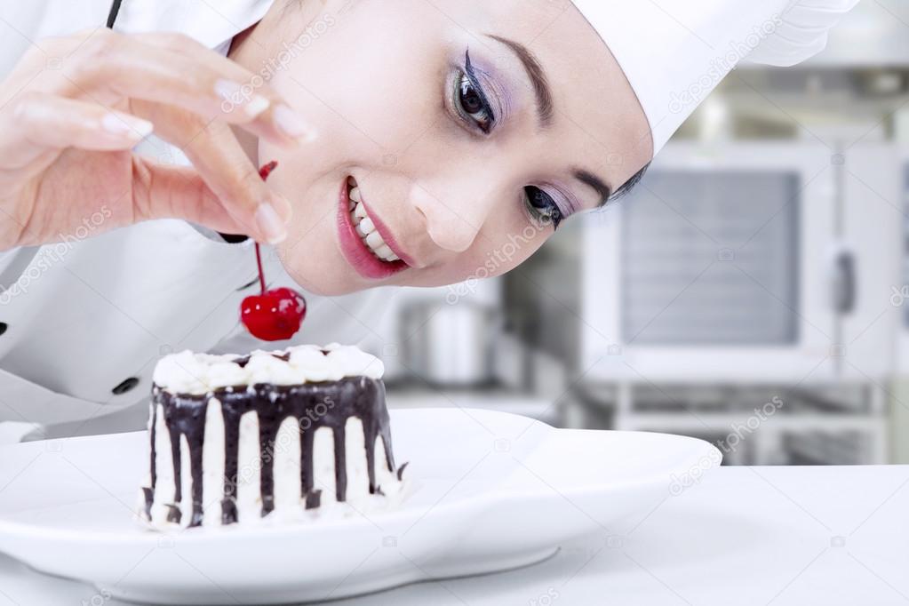 Beautiful chef decorating cake — Stock Photo © realinemedia #22525397
