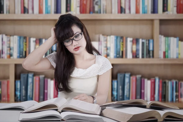 Confused student reading many books 1 - Stock Image - Everypixel
