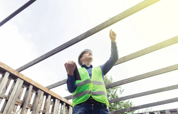 Building inspector. Man in a hard hat and a yellow reflective vest ...