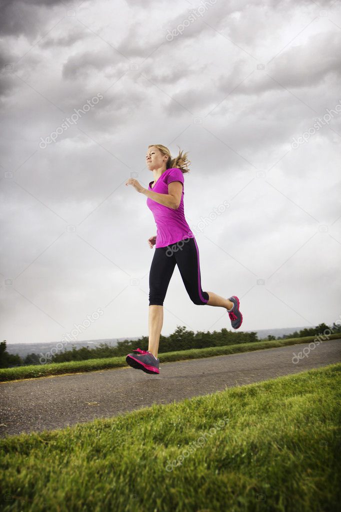 Female Runner working out dramatic clouds Stock Photo by ©yobro10 40844199