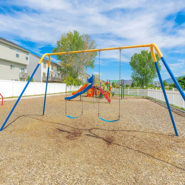 Square Whispy white clouds Small community playground near the fenced residential houses at Utah ...