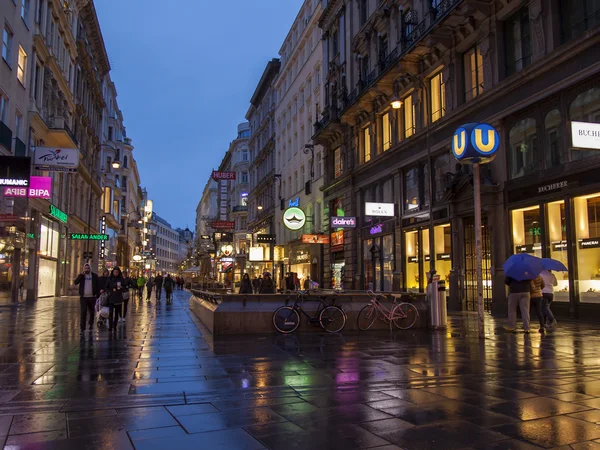 Vienna , Austria. Tourists walk on the evening streets in rainy weather ...