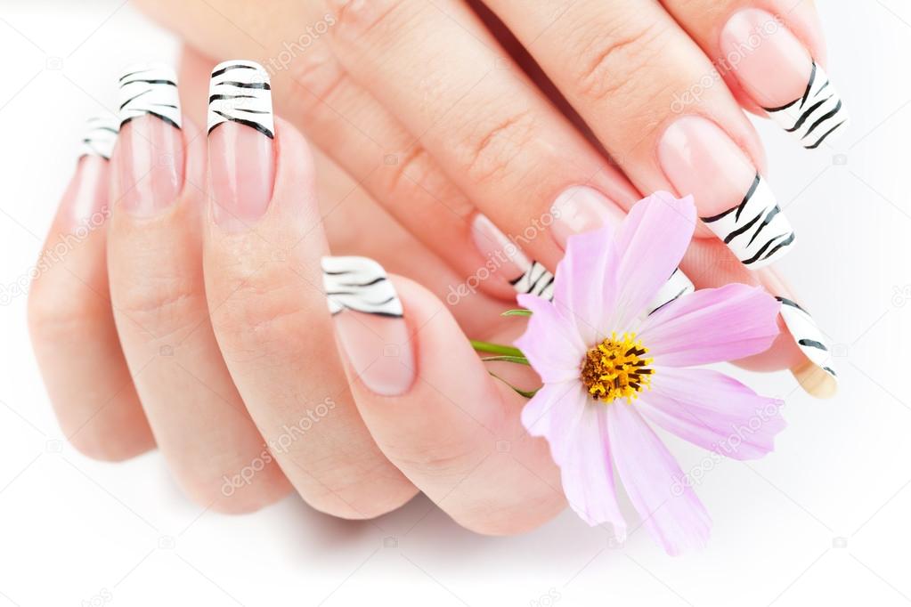 Hands with striped manicure relaxing with flowers — Stock Photo © titov ...